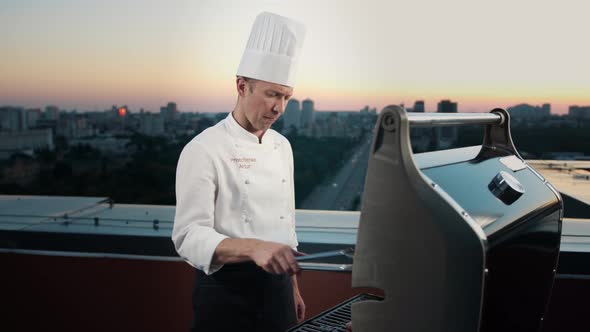 A professional Chef prepares a barbecue on the rooftop of a skyscraper ...