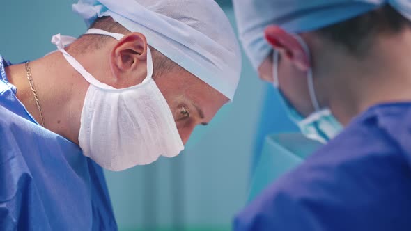 Surgery team in operating room. Side view of surgeon performing ...