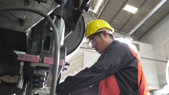 Asian worker operate stamping machine working wear safety uniform ...