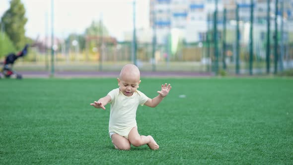 Excited Toddler Boy Loses Balance and Falls Down on Grass, Stock Footage
