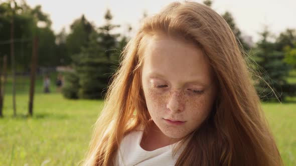 Gloomy Face of Sad Ginger Little Girl with Freckles with Lowered Eyes ...