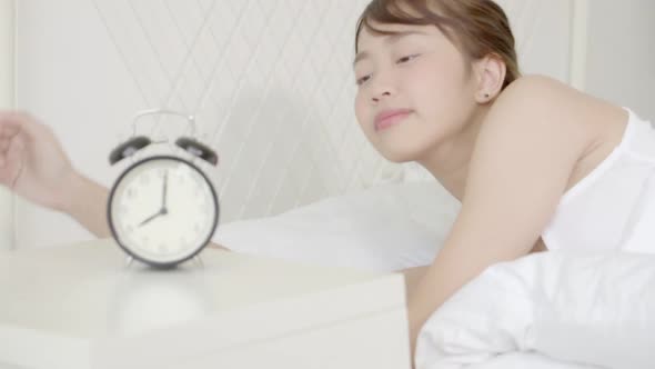 Beautiful young asian woman panicked waking up in the morning looking ...