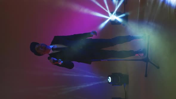 Vertical Video. Stylish Man in a Jacket Singer with a Microphone Stand ...