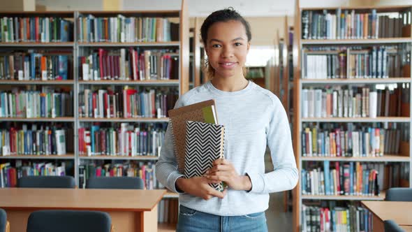 African American Lady Standing in Library with Books Smiling Looking at ...