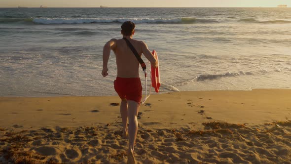 Male lifeguard running along the beach, Stock Footage | VideoHive