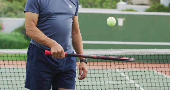 Video of midsection of biracial senior man holding racket and tossing ...