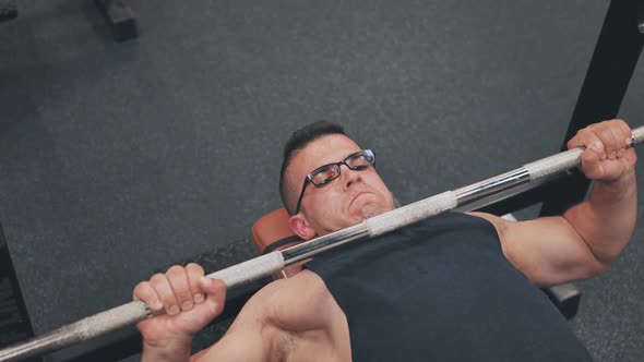 An Arab Man Shakes His Chest with a Barbell Lying Down, Stock Footage