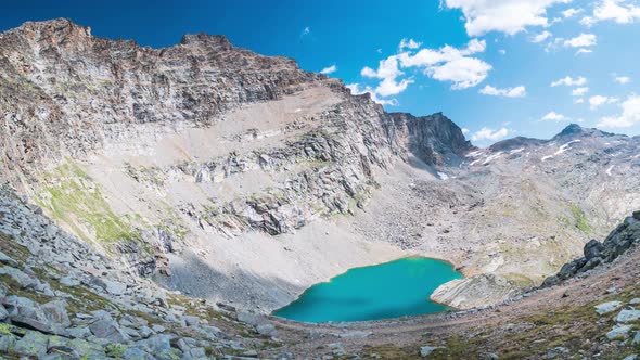 PAN: Idyllic blue alpine lake high up on the mountains, scenic ...