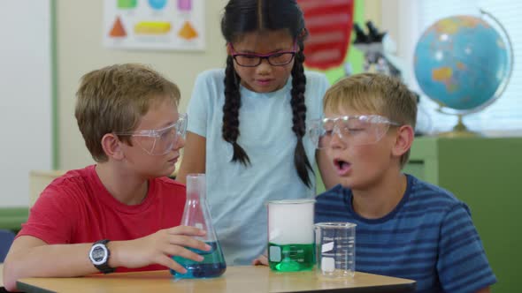 Three kids in classroom looking at science experiment, Stock Footage