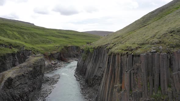 Aerial View Of Ravine Flowing Through Studlagil Basalt Canyon With ...
