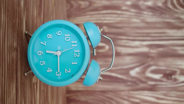 Vertical Video with Sound White Alarm Clock on a Wooden Background ...