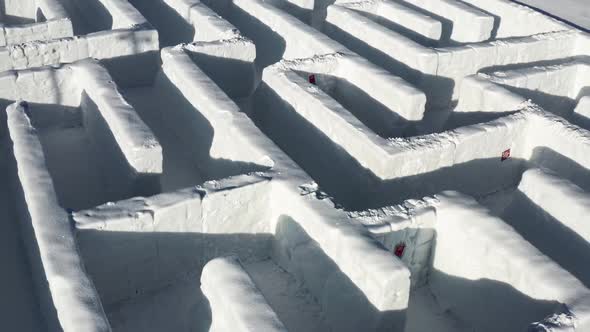 Sunshine at white snowy winter labyrinth, maze puzzle location, aerial ...
