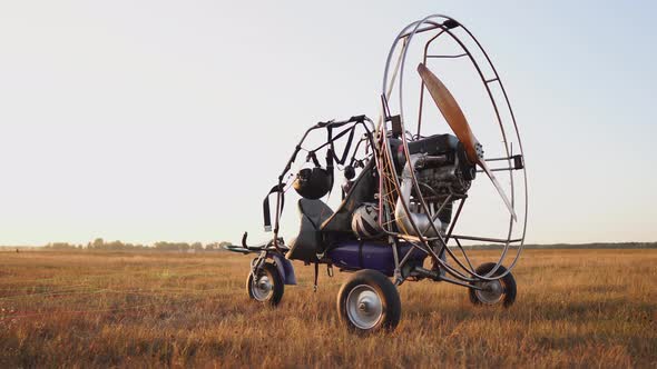 The Motor Paraglider Stands in the Field at Sunset with a Wooden ...