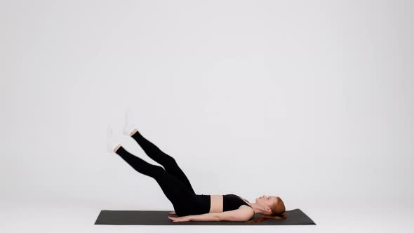 Fit Young Woman In Sportswear Training In Studio Doing Leg Rise ...