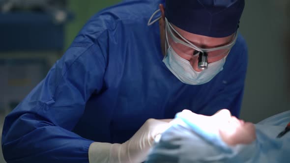 Concentrated Surgeon Making Dissection on Face of Patient Lying on ...