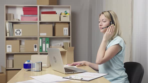 Female Postal Worker Talks Using Headset Servicing Clients Remotely at ...