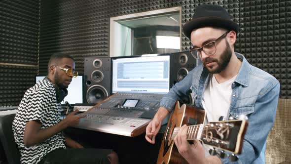 Musician Playing Guitar to Sound Engineer in Recording Studio, Stock ...