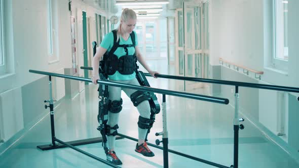 Young Woman is Using Exosuit for Walking in the Hospital, Stock Footage