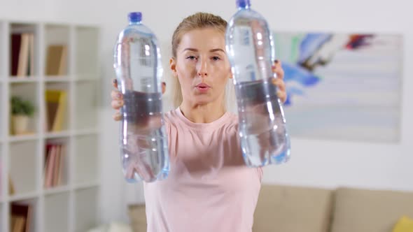 Woman Doing Exercise with Water Bottles and Looking at Camera, Stock ...