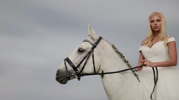 Gorgeous Blonde in a White Wedding Dress Riding a Horse, Stock Footage