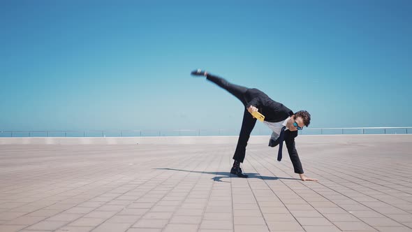 Flexible and cool businessman doing acrobatic tricks outdoor, Stock Footage