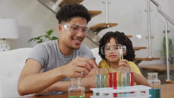 Happy biracial man and his son making chemistry experiments, Stock Footage