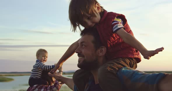 Boys Whirl with Their Parents on Their Necks, Stock Footage | VideoHive