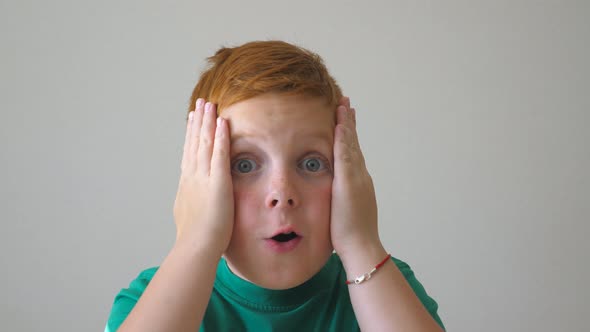 Close Up of Adorable Redhaired Boy Grabbing His Head and Showing Joy on ...