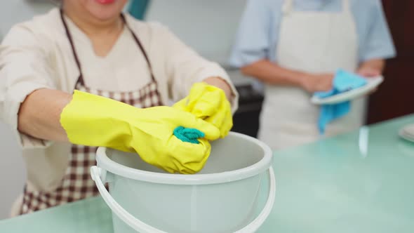 Close up of Asian young aged housewife twisting wet rag to clean the ...