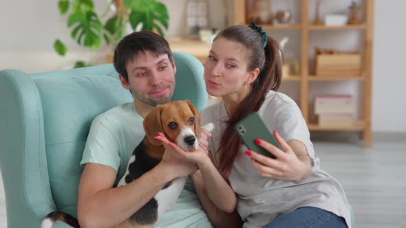 Couple Take a Selfie with Dog on Smartphone While Sitting on Sofa Spbi ...