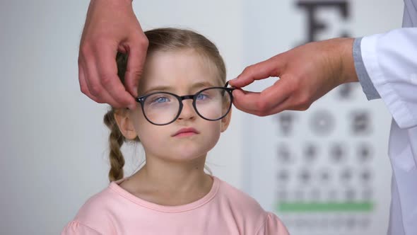 Capricious Little Girl Rejecting Eyeglasses From Optician, Feels ...