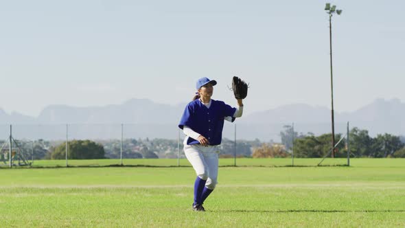 Caucasian female baseball player, fielder jumping, catching and ...
