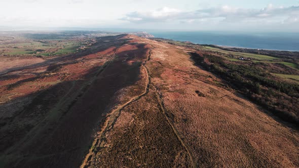 AERIAL: Sideways pan showing footpath along ridgeline during golden ...