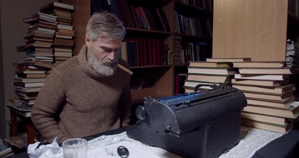 Ernest Hemingway is cutting a cigar and putting it in his mouth ...