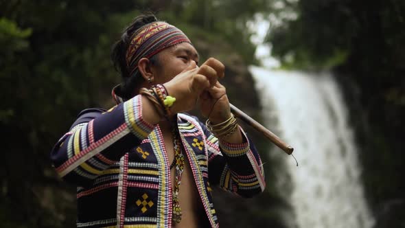 orbit shot of Indigenous person playing Kubing tribal instrument ...