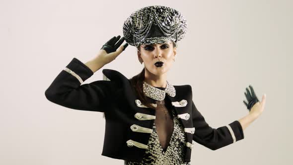 European Female Singer in a Hat is Singing and Dancing on a White Stage ...