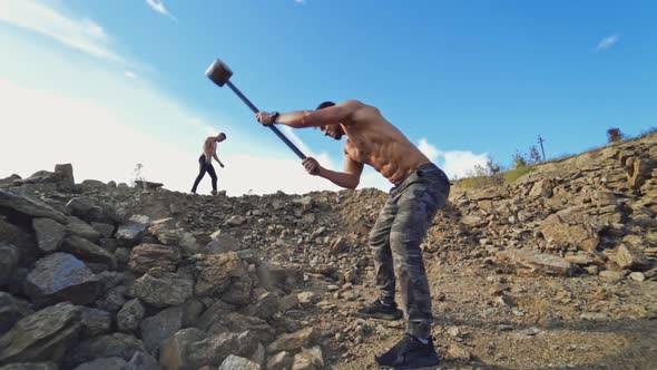 Athletic men doing hard exercises with stones. Shirtless sportsman ...