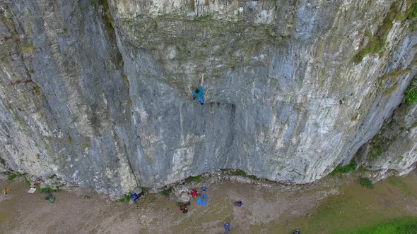 A man falls and is saved by his rope while rock climbing up a mountain ...
