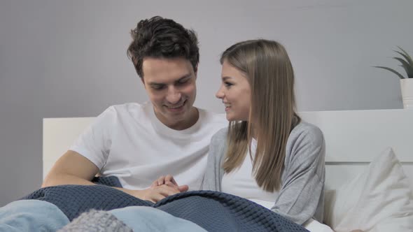 Young Couple Having Romantic Talk While Relaxing in Bed, Stock Footage