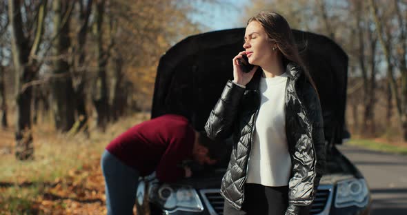 Woman Calling Auto Repair Service By Phone Man Repairing Car on the ...