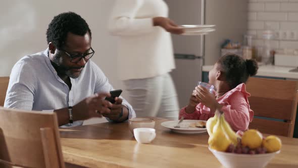 Mother clearing dishes off after breakfast, Stock Footage | VideoHive