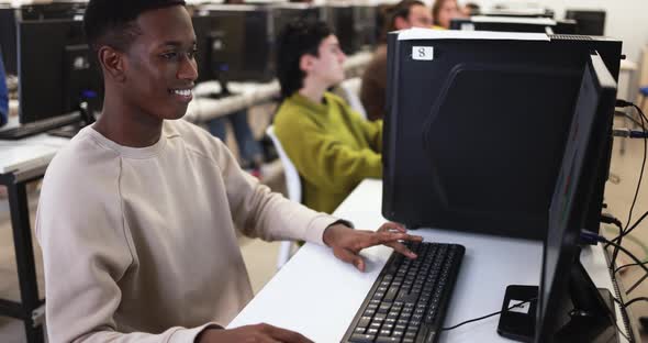 Young multiracial people using computers inside school classroom at ...