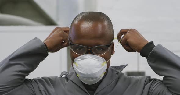 African American male car mechanic putting a face mask on, Stock Footage