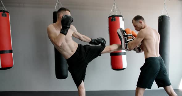 The Kickboxer is Practising His Knee Blow with Trainer in Slow Motion ...