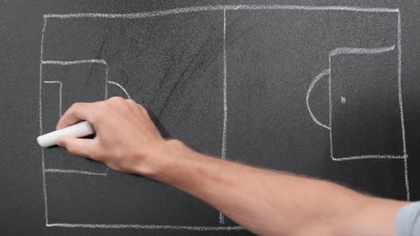 Coach drawing soccer field on blackboard using chalk., Stock Footage