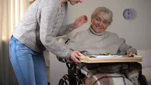 Female Volunteer Serving Dinner to Handicapped Old Women, Elderly ...