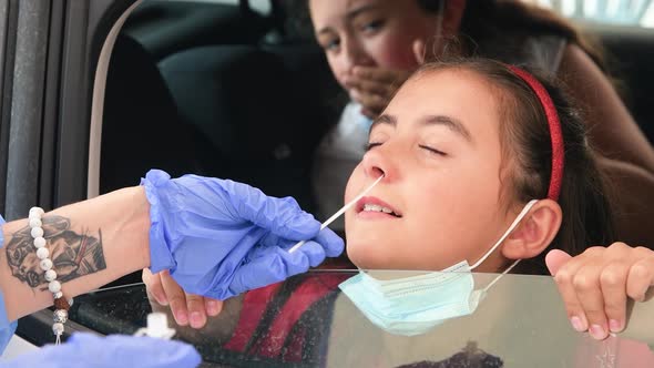 Pediatrician Taking Nasal Mucus Test Sample From Elementary Age Girl's ...