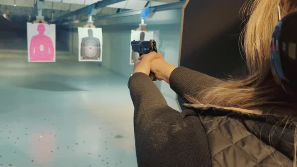 Woman Shooting at a Target with a Pistol in a Shooting Range, Stock Footage