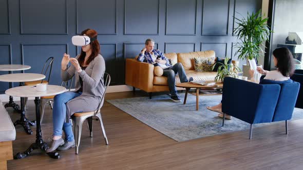 Businesswoman using virtual reality headset in the lobby at office 4k ...