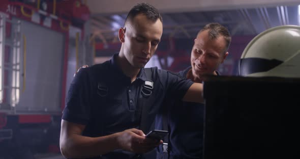 Fireman Using Smartphone and Talking with Colleague, Stock Footage